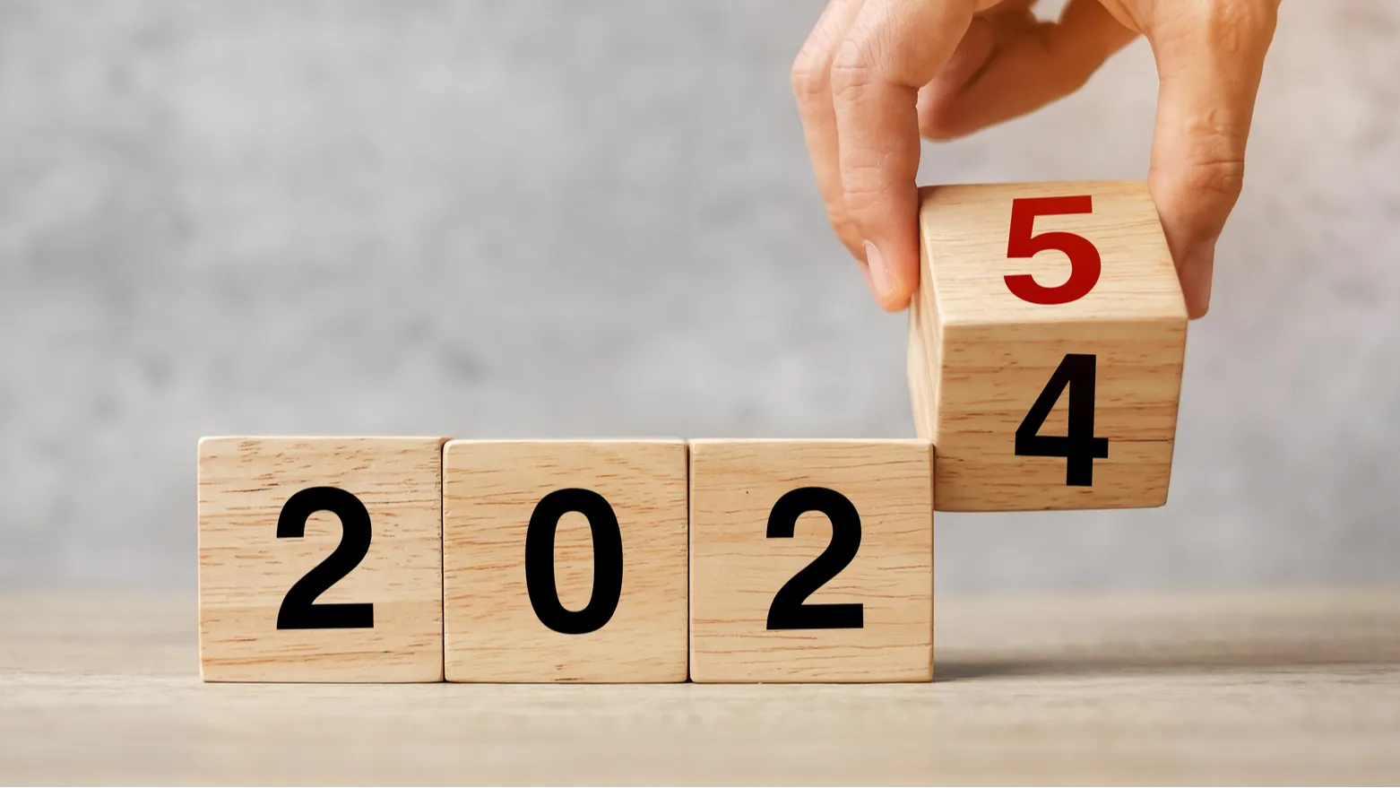 hand flipping block 2024 to 2025 text on table - NashvilleGab